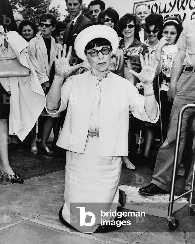 Image of Edith Head, leaving hand prints in cement outside the Hollywood