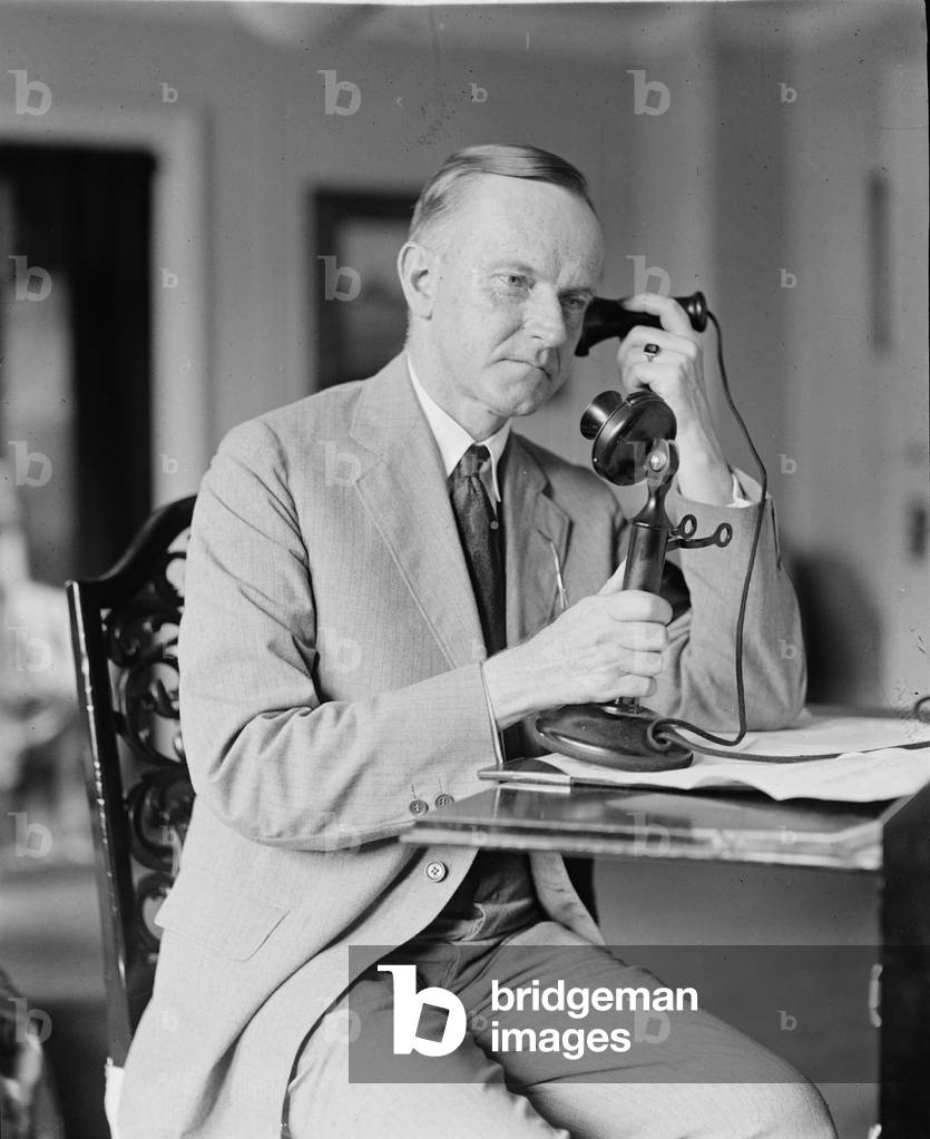 Image of President Calvin Coolidge (1872-33) using a telephone, two ...