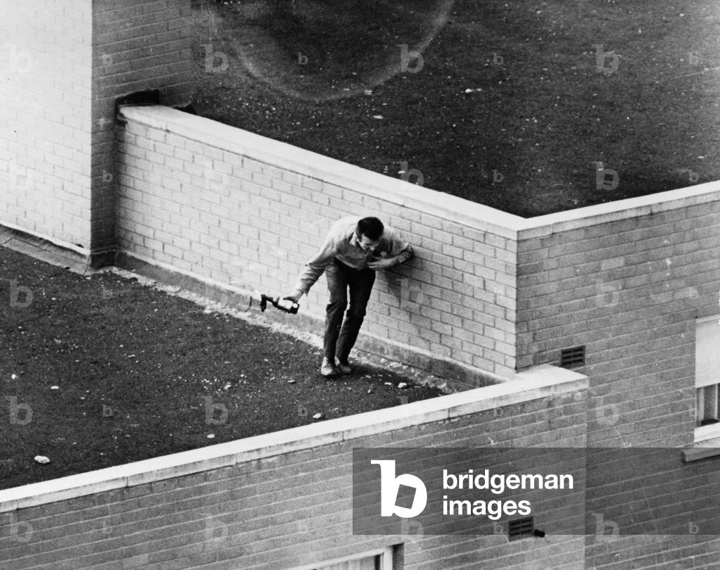 Image of BOGSIDE RIOT, 1970s A man on a Londonderry roof prepares
