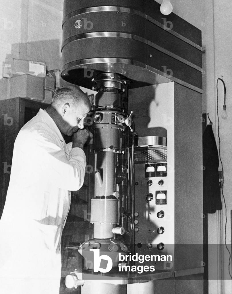 Image of Scientist using an electron microscope in a laboratory ...