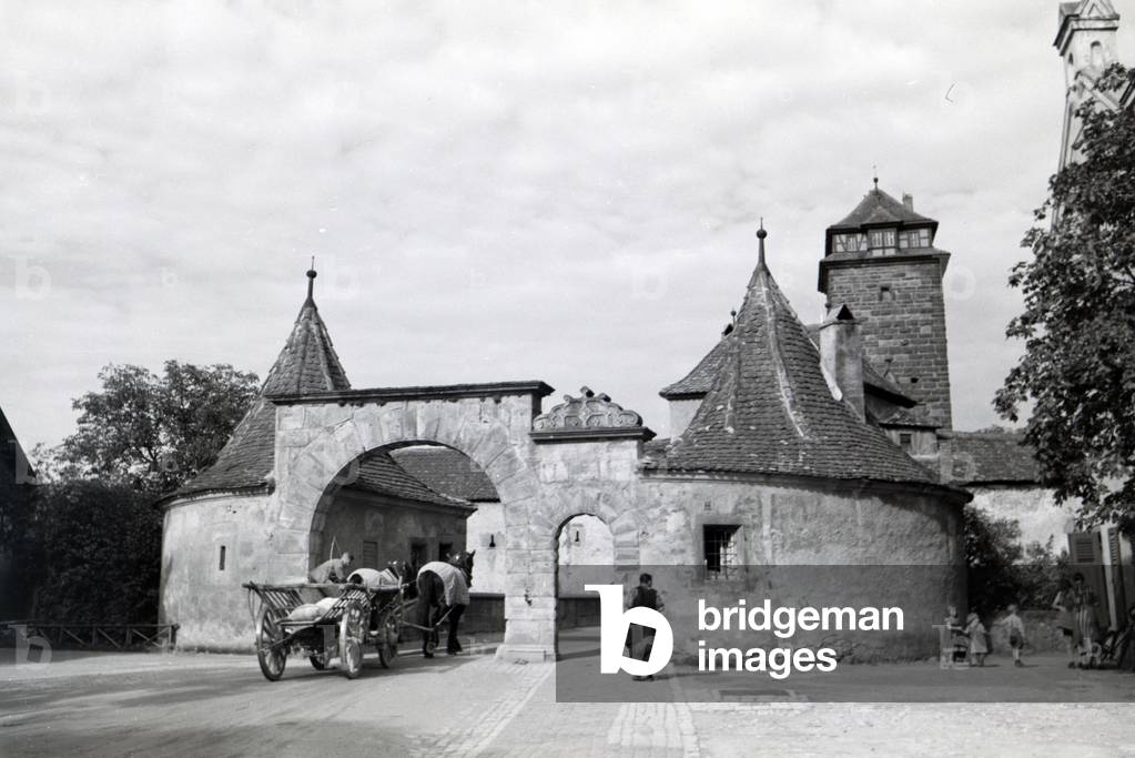 Image of A loaded horse-drawn carriage is driving through the castle gate,