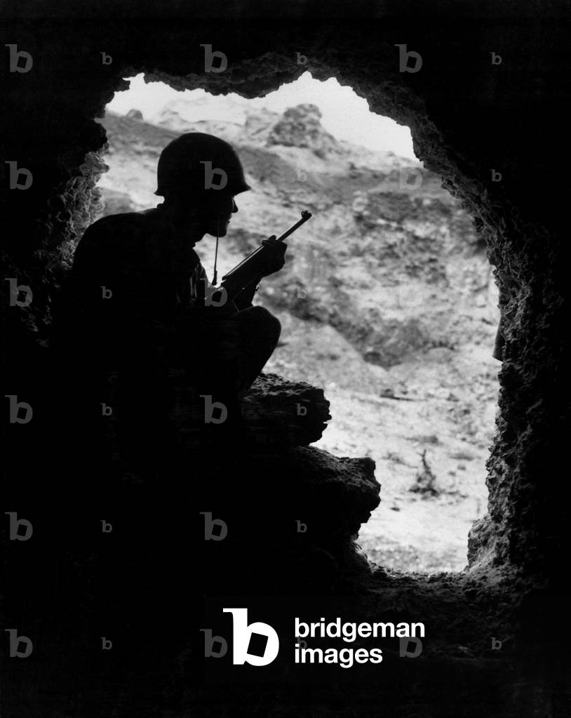 Image of Marine rifleman positioned in an cave to pick off Japanese