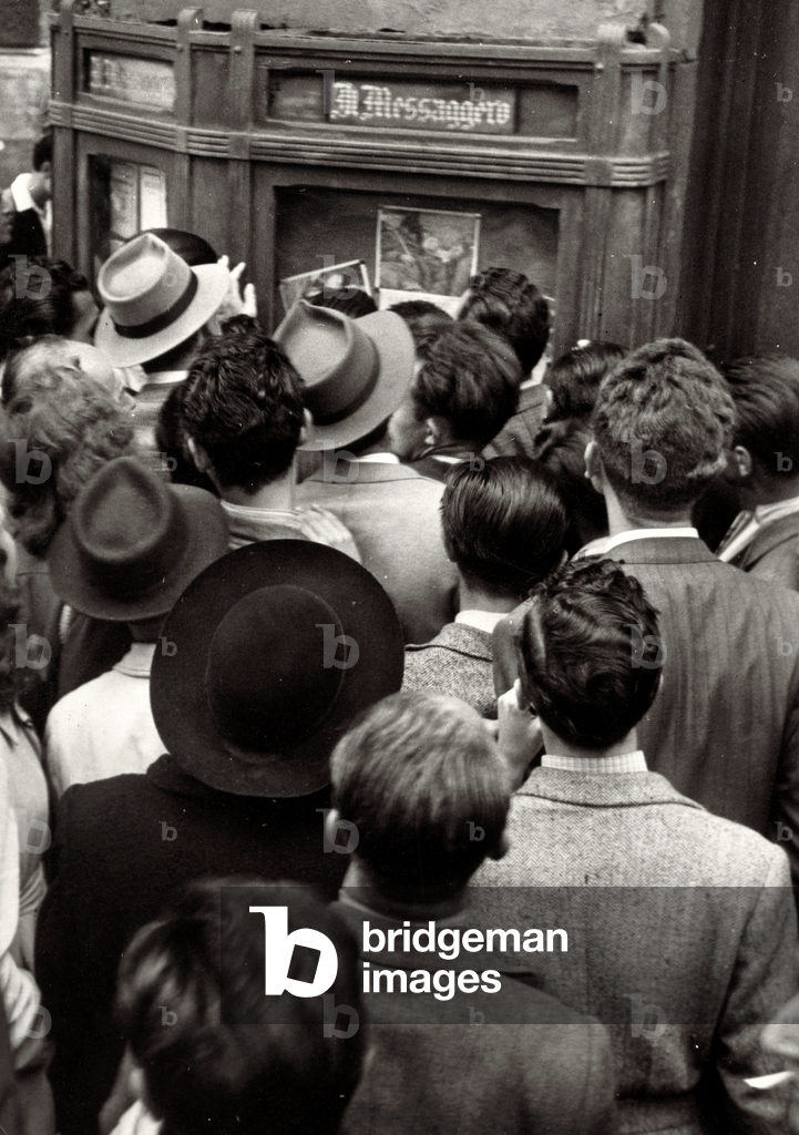 Image of Crowd gathered around a bulletin board with pictures of ...