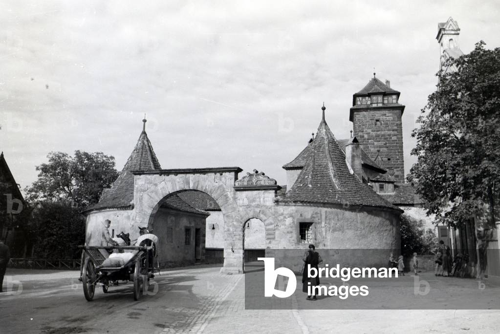 Image of A loaded horse-drawn carriage is driving through the castle gate,