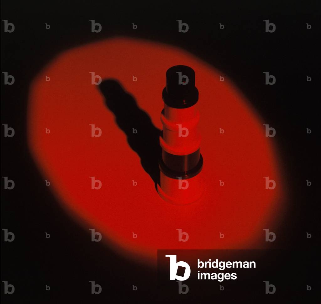 Image of Red light shining on object in dark causing black shadow