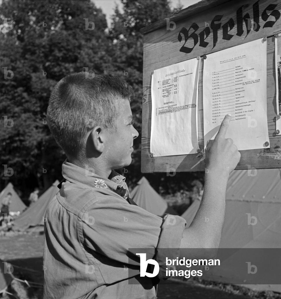Image of A Hitler youth reading the order of the day on