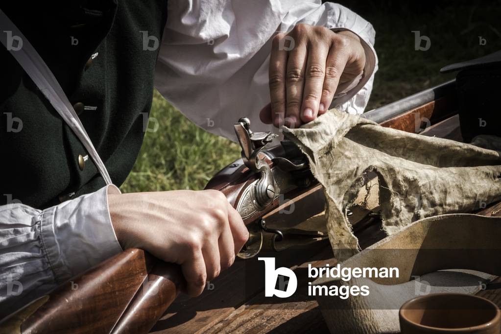 Image of Historical reenactment: Soldier cleaning his muzzle-loading ...
