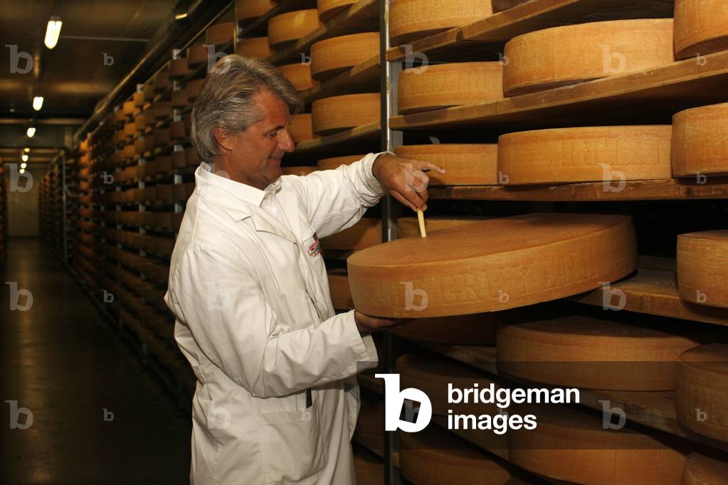 Image of Cheesemaker Sampling Cheese, Switzerland (photo)