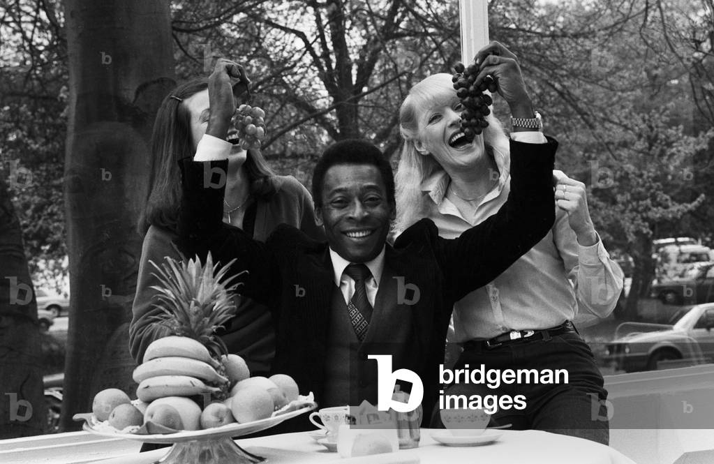 Image of Brazilian football player Pele with two ladies at the breakfast