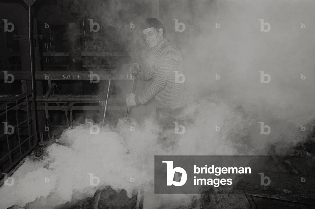 Image of A nightshift Coalite worker breaks up ash deposits with an by ...