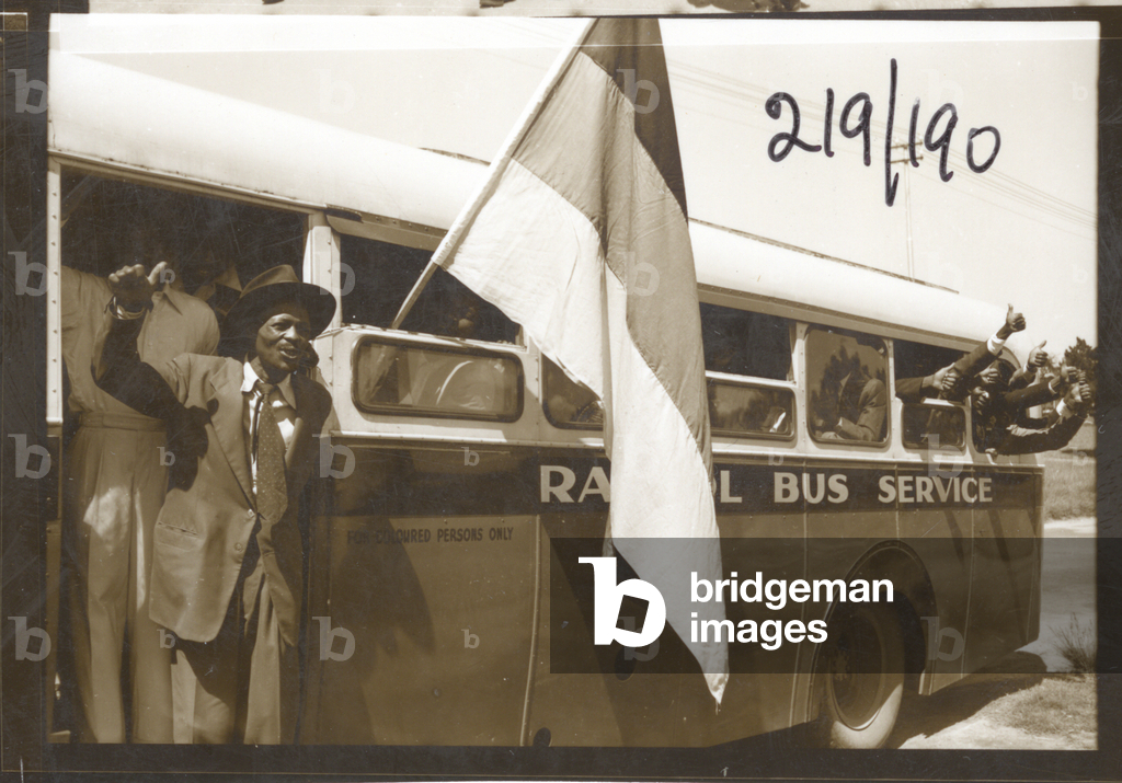 Image of A man in the door of a 1950s style bus