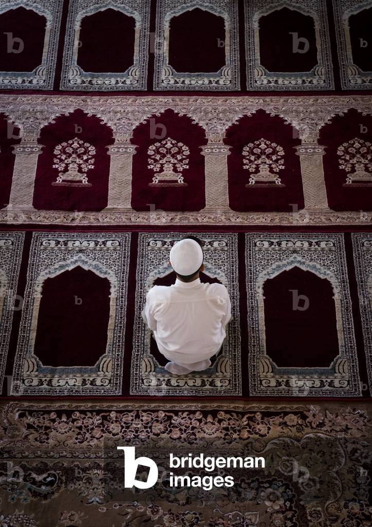 Image of Iranian Shiite Muslim Prayer Sits on a Carpet in a