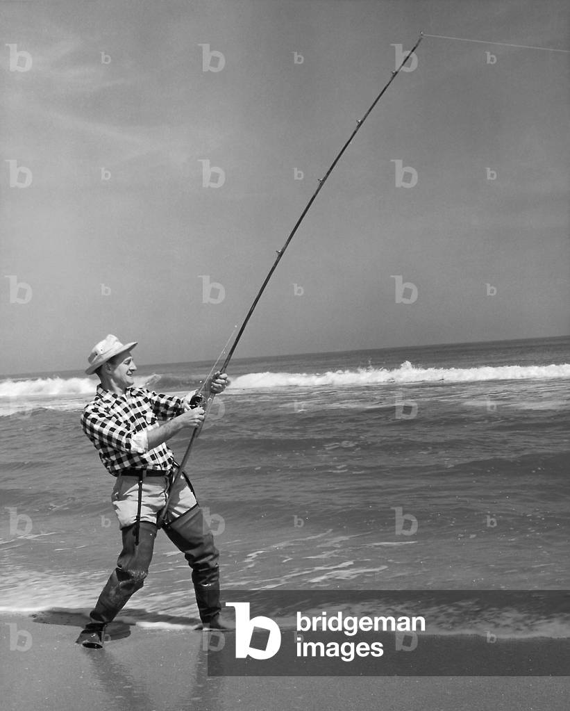 Image of Man fishing from shore of ocean (b/w photo)