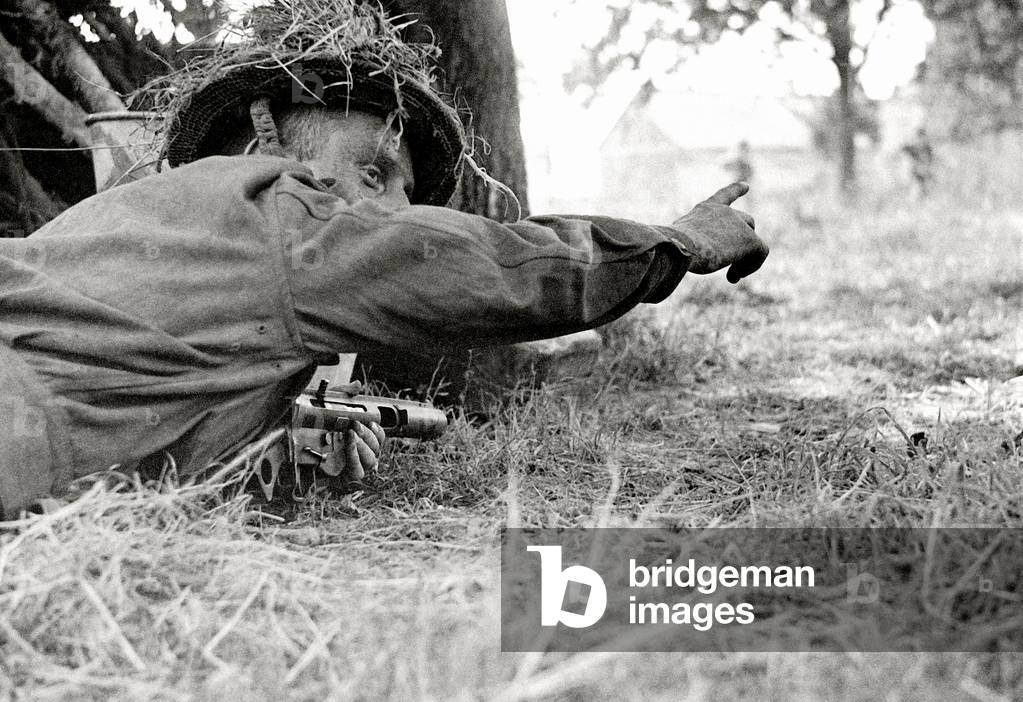 Image of A British soldier with a submachine gun on the ground, by ...