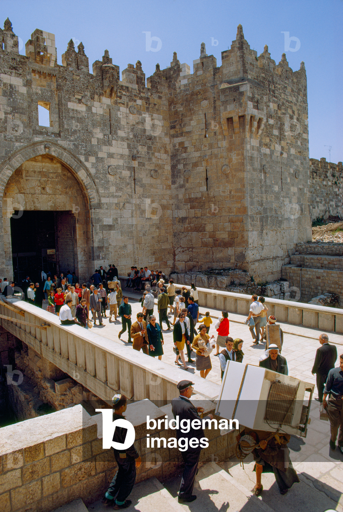 Image of Pedestrians funnel through tall arched stone entrance Damascus ...