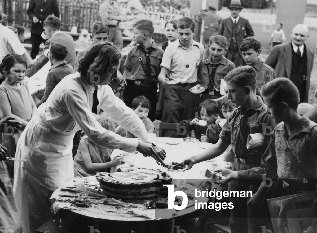 Image of Hitler's birthday cake is being shared, 1934 (b/w photo)