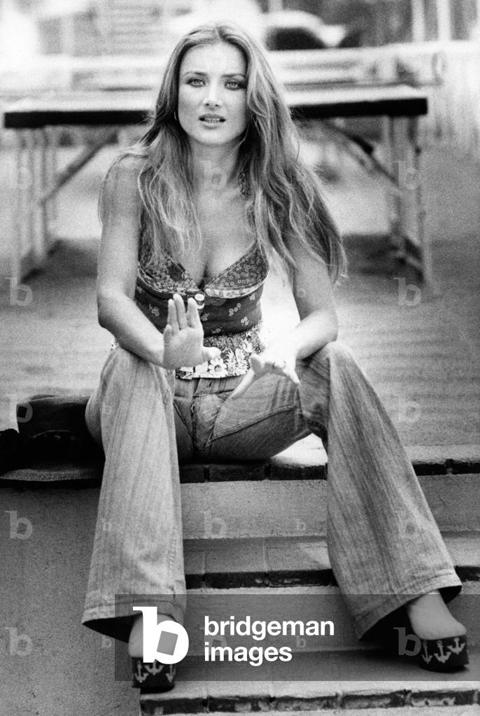Image of Barbara Bouchet seated on the steps of a stairs, 1973