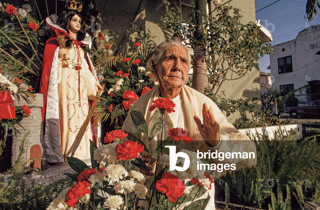 Image of Cuban-born woman Regina Espinosa tends to St. Barbara statue ...