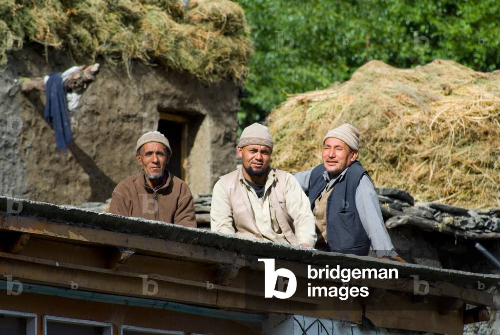 Image of Three Balti men on roof of house in remote Himalayan