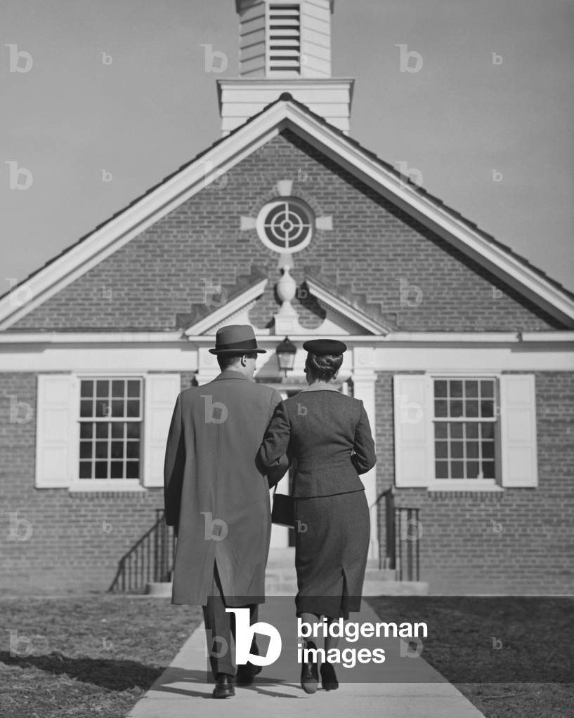 Image of Rear view of a man and woman walking to church
