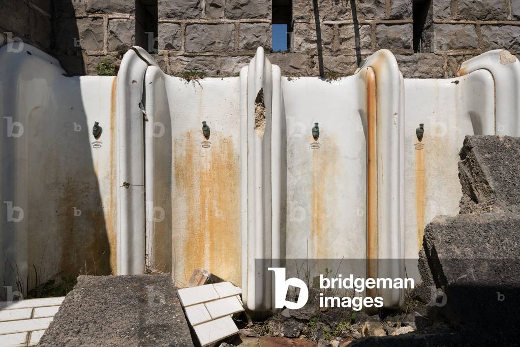 Image of Detail of stained and damaged urinals in the gentlemen's toilets