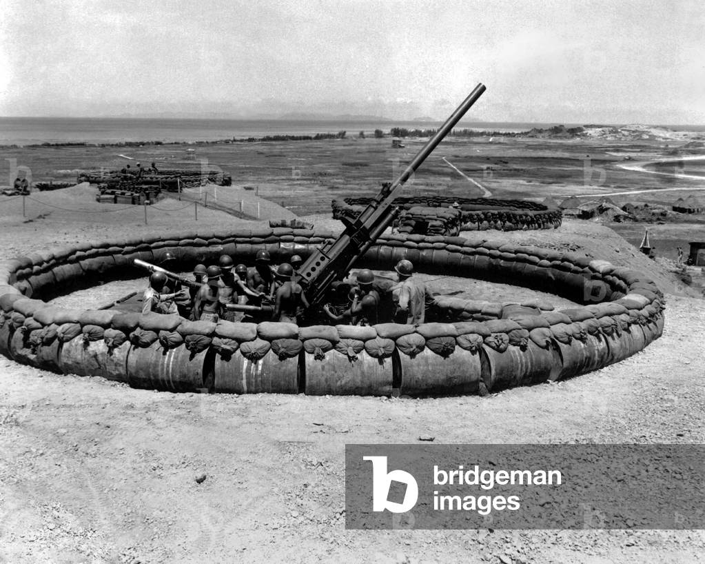 Image of 90mm anti-aircraft gun emplacement with crew in pit on Okinawa,