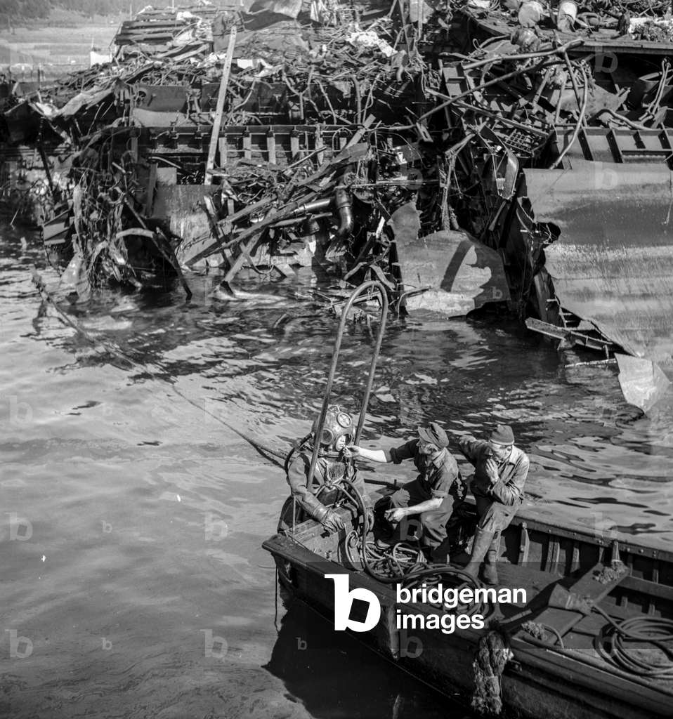Image of Diver and salvage workers salvaging the remains of WWII German ...