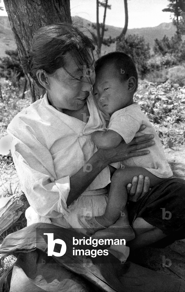 Image of A mother holds her toddler child on her lap, Korea, by ...